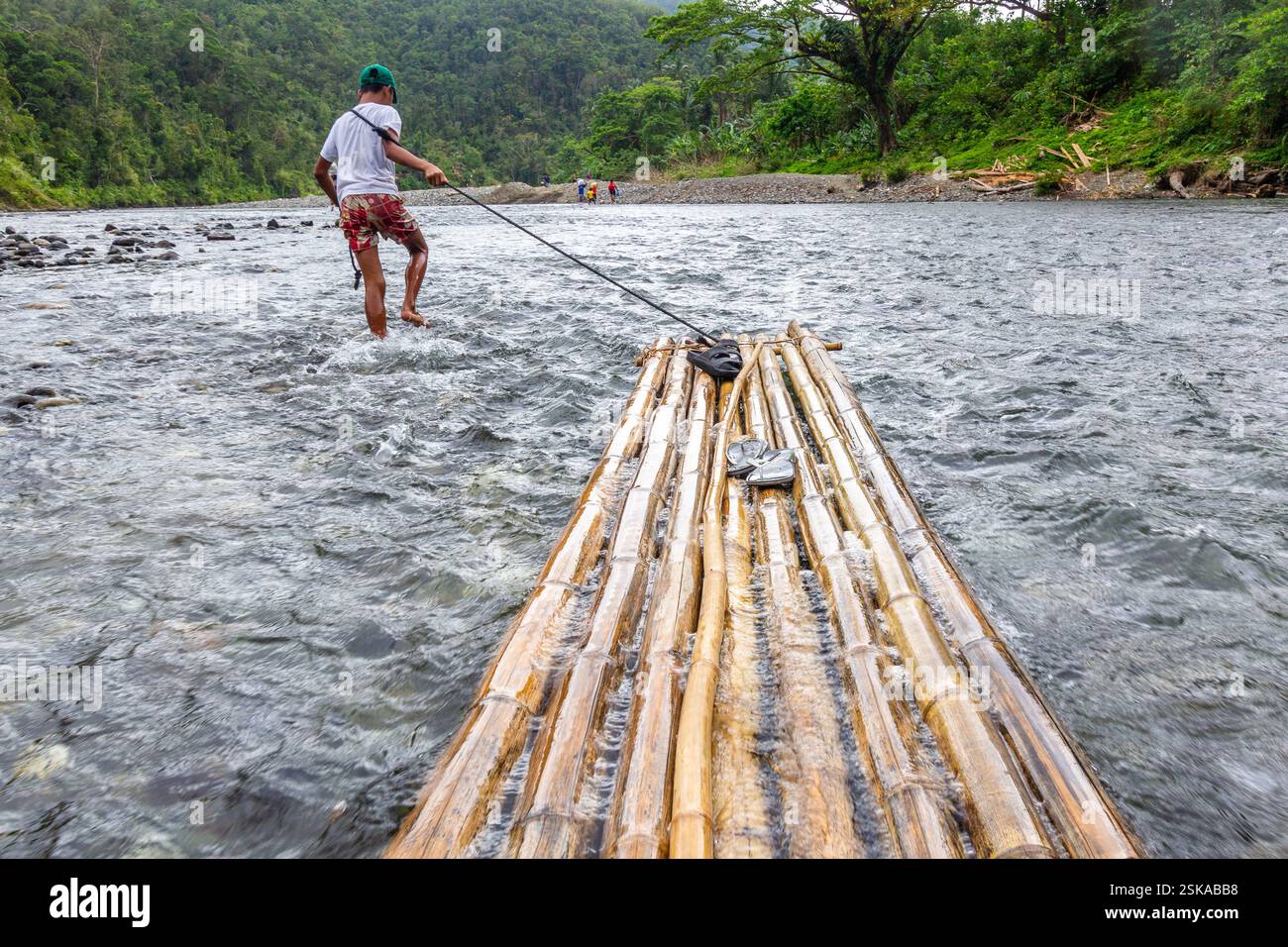 A Filipino boy leads his bamboo raft through the shallow parts of ...