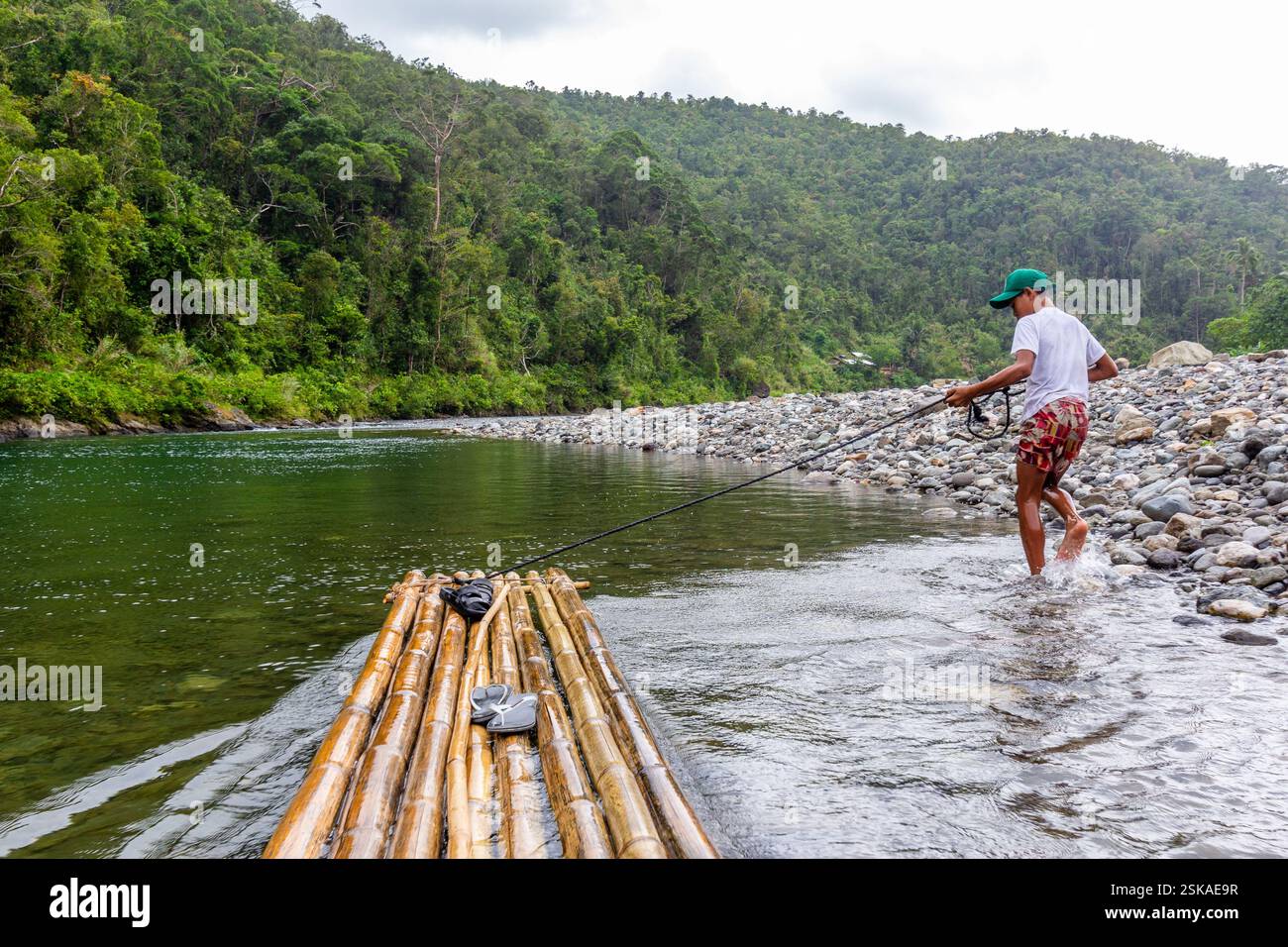 A Filipino boy leads his bamboo raft through the shallow parts of ...