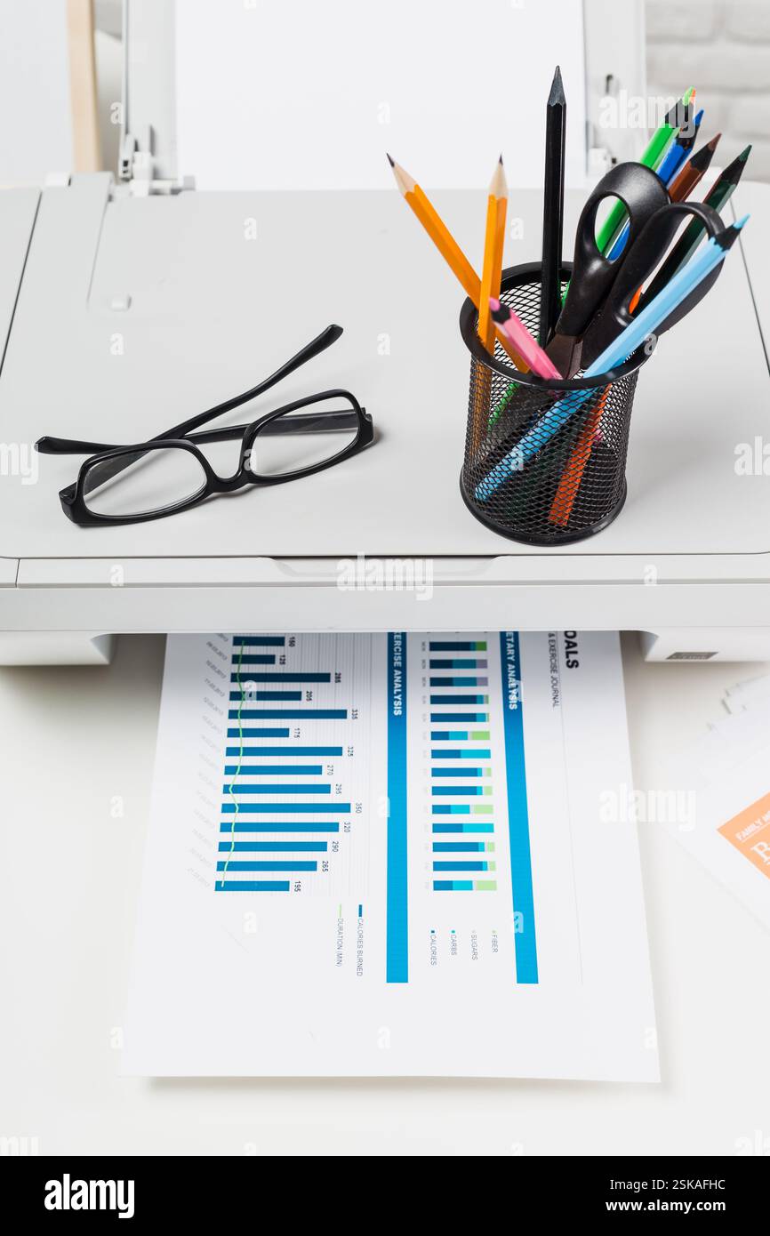 Office workstation with documents printing and stationery on desk ...