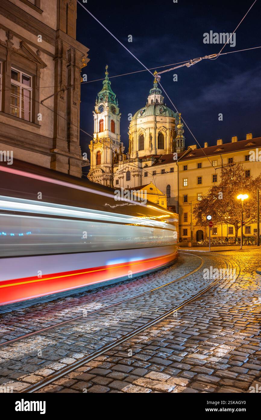 A tram moves swiftly in the heart of Prague's Lesser Town Square at ...