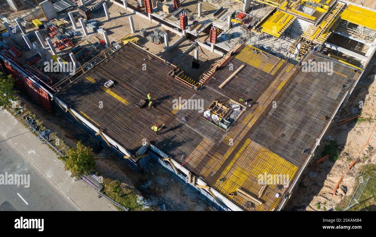 Aerial view of a construction site with workers on a partially built ...