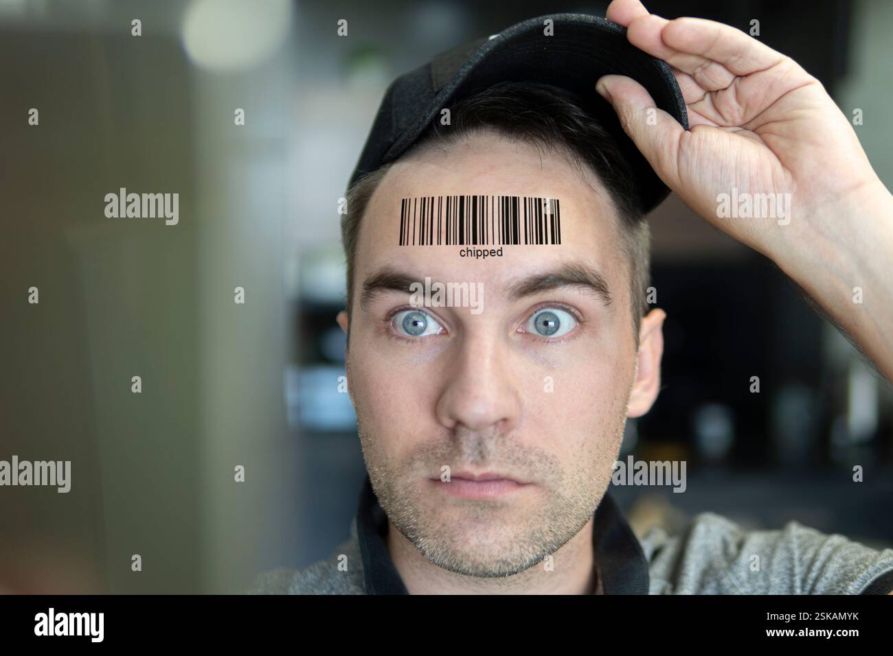 A man with a stupid expression looks at his qr code on his head. The ...
