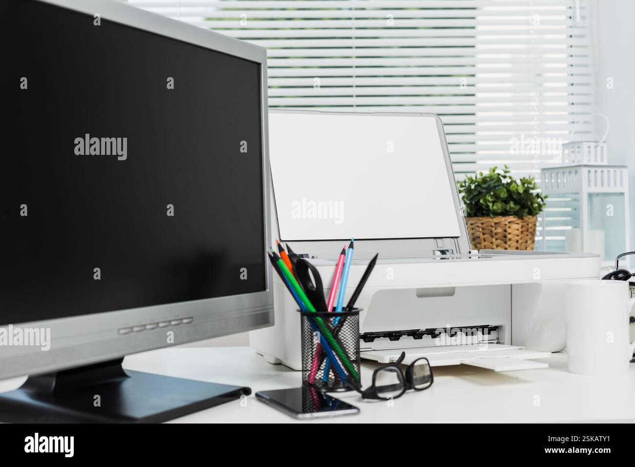 Modern office workspace featuring computer monitor, printer, and ...