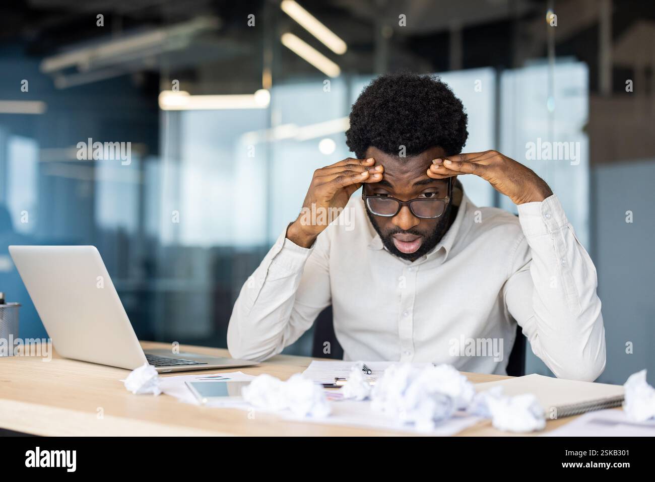 Disappointed and frustrated man sitting inside office at workplace ...