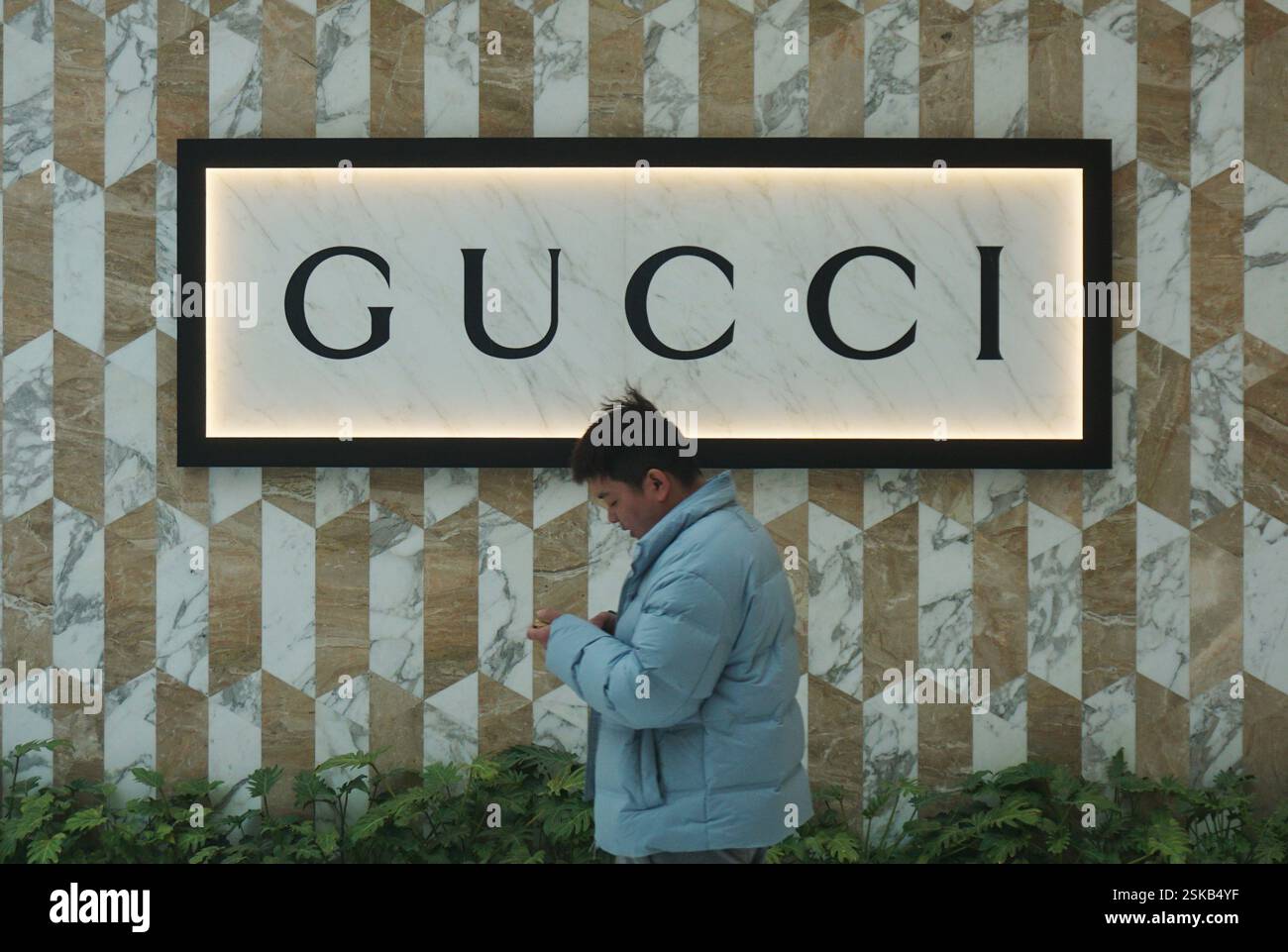 Customers walk past a GUCCI store in Hangzhou, Zhejiang Province, China ...