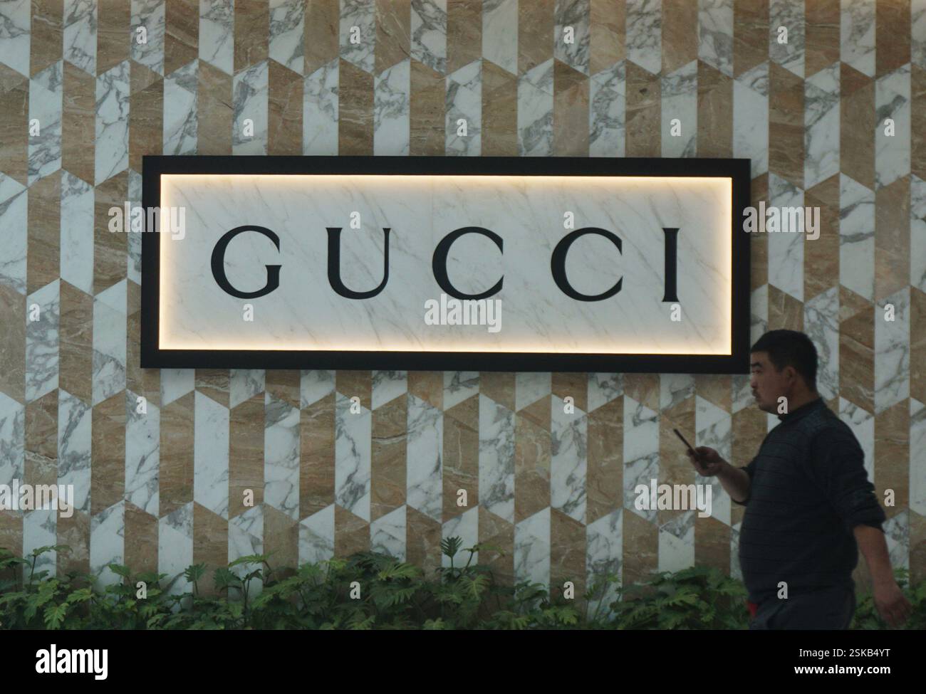 Customers walk past a GUCCI store in Hangzhou, Zhejiang Province, China ...