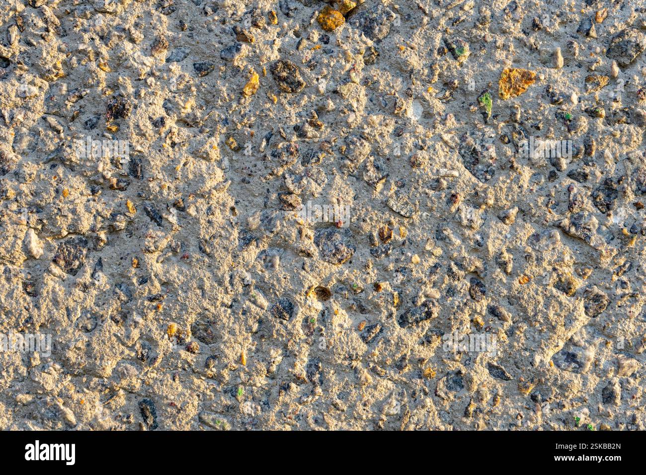 The concrete surface shows a rough and varied texture with scattered ...