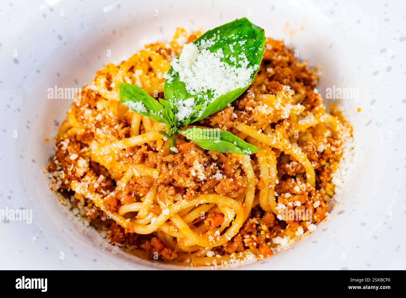 A tempting pasta dish is presented in a bowl, topped with fresh herbs ...