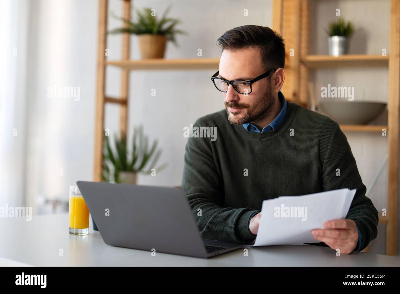Business man accountant analyst holding documents, work at laptop ...