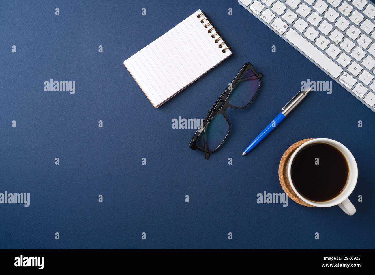 Workspace with keyboard, laptop, office supplies, pen and coffee cup ...