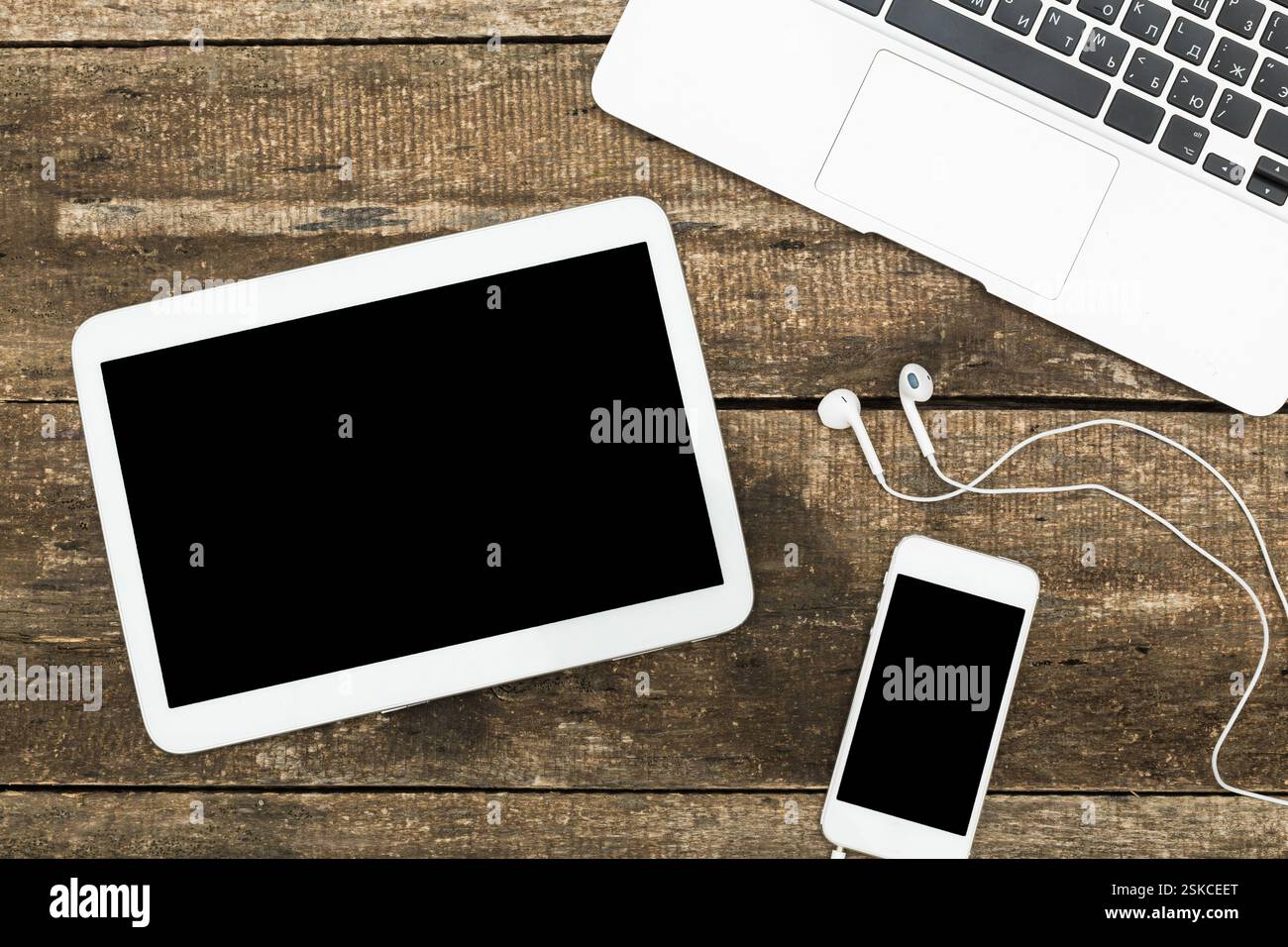 Workspace setup featuring tablet, smartphone, and laptop on rustic ...
