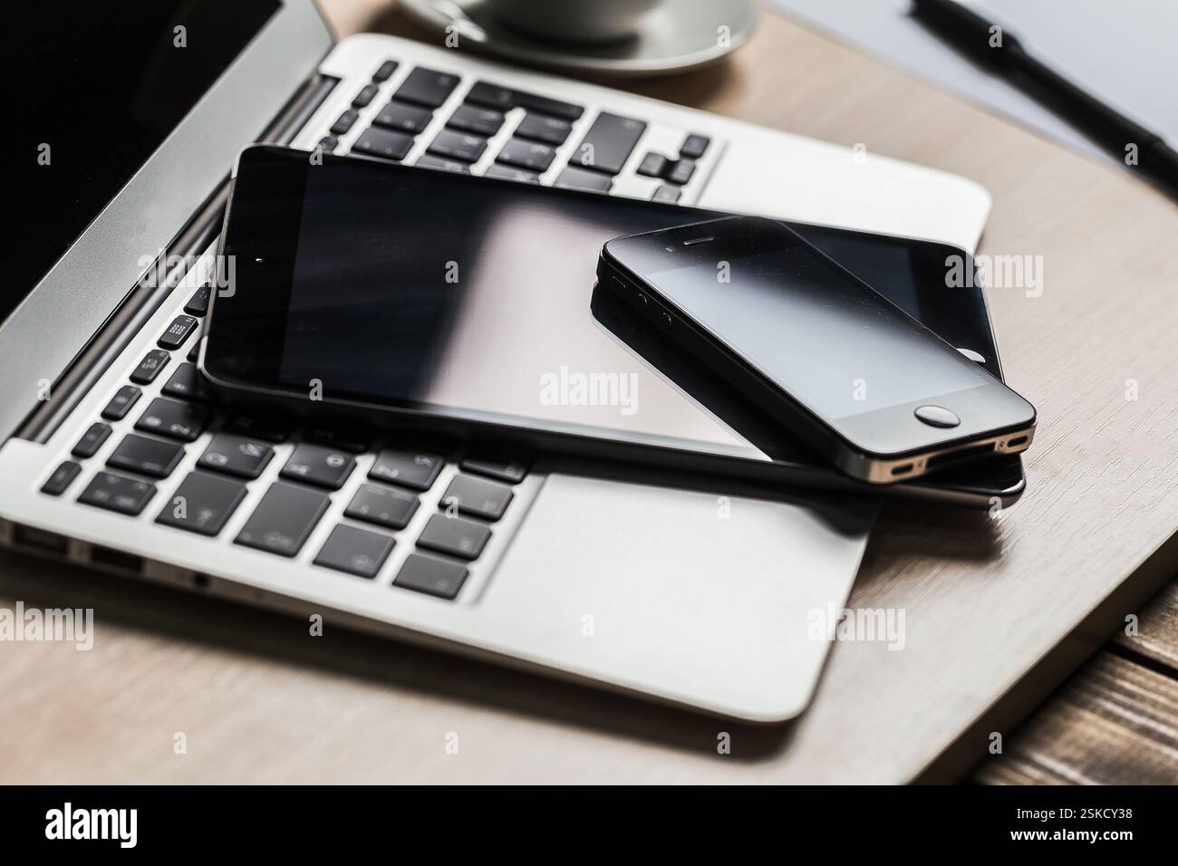 Workstation setup with laptop, tablet, and smartphone on a wooden desk ...