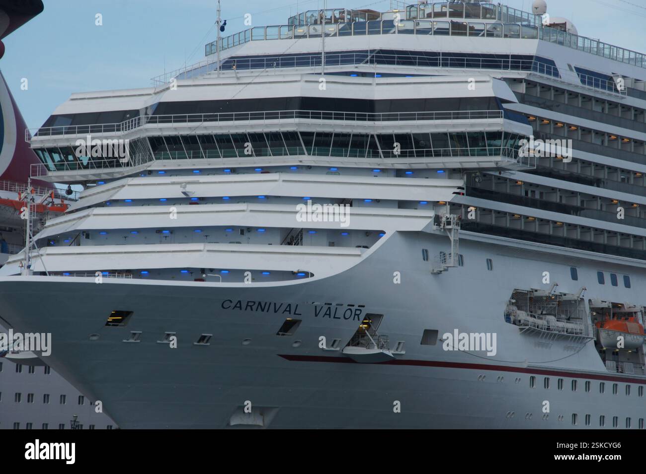 Carnival Valor, a large white cruise ship with blue accents, is docked ...