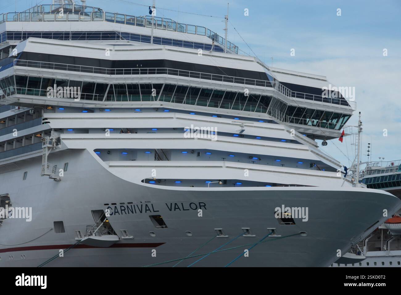 Carnival VALOR, a large white cruise ship with blue accents, docked in ...