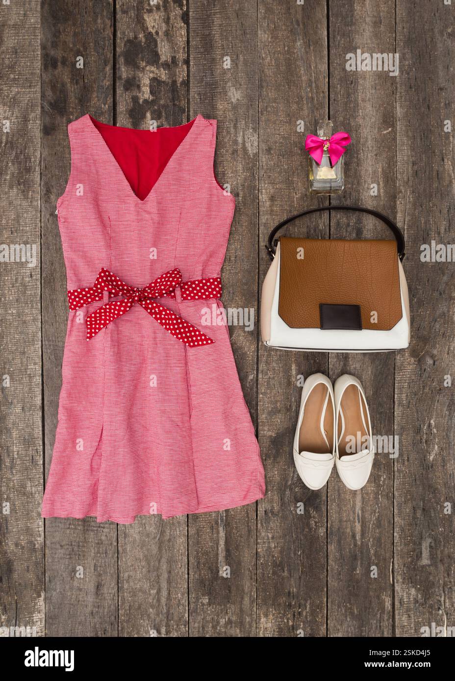 Charming pink dress laid out with accessories on rustic wooden ...