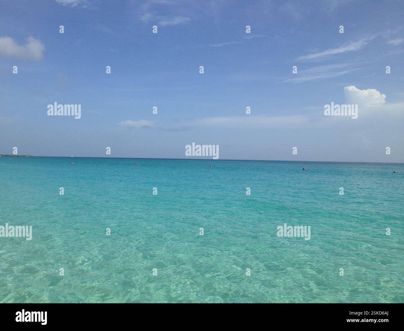 Beach. Clear blue sky with white clouds. Calm turquoise water with red ...