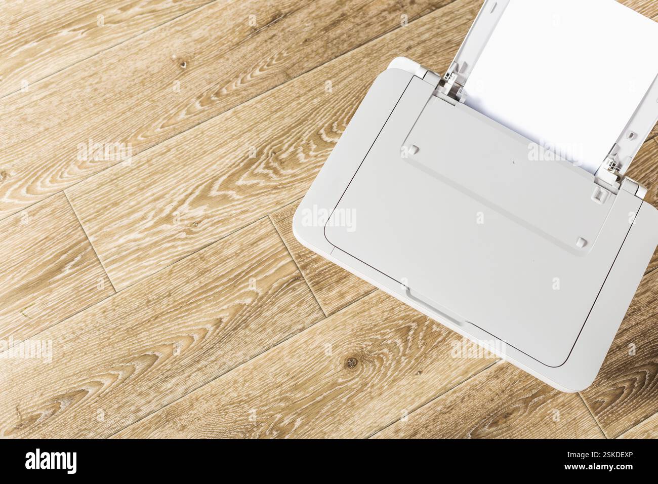Printer placed on a wooden floor surrounded by a clean workspace with ...