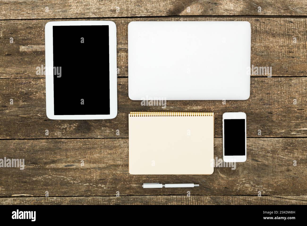 Collection of electronic devices and stationery arranged on wooden ...
