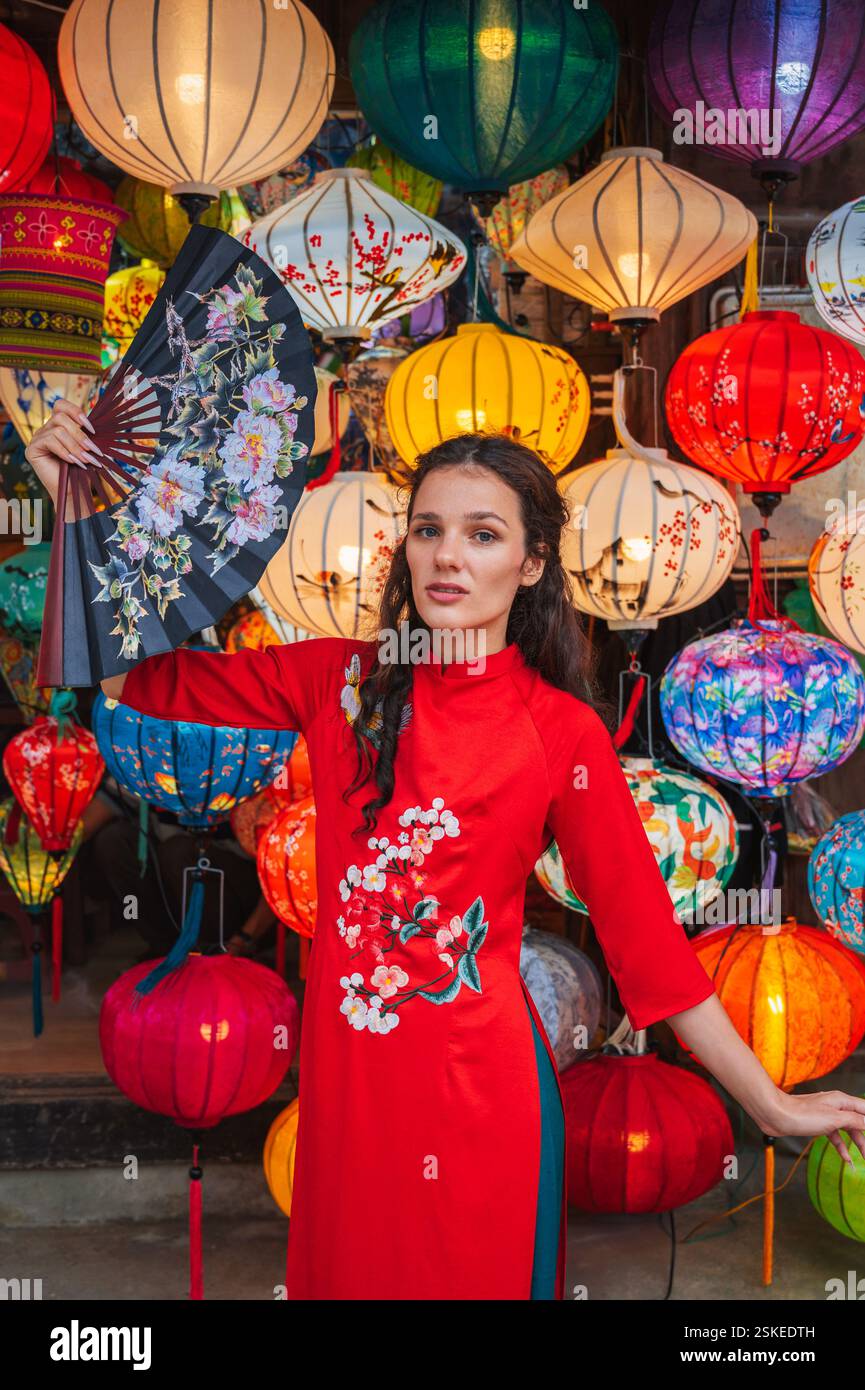A woman in traditional Vietnamese clothes against the background of lanterns in the ancient city ...