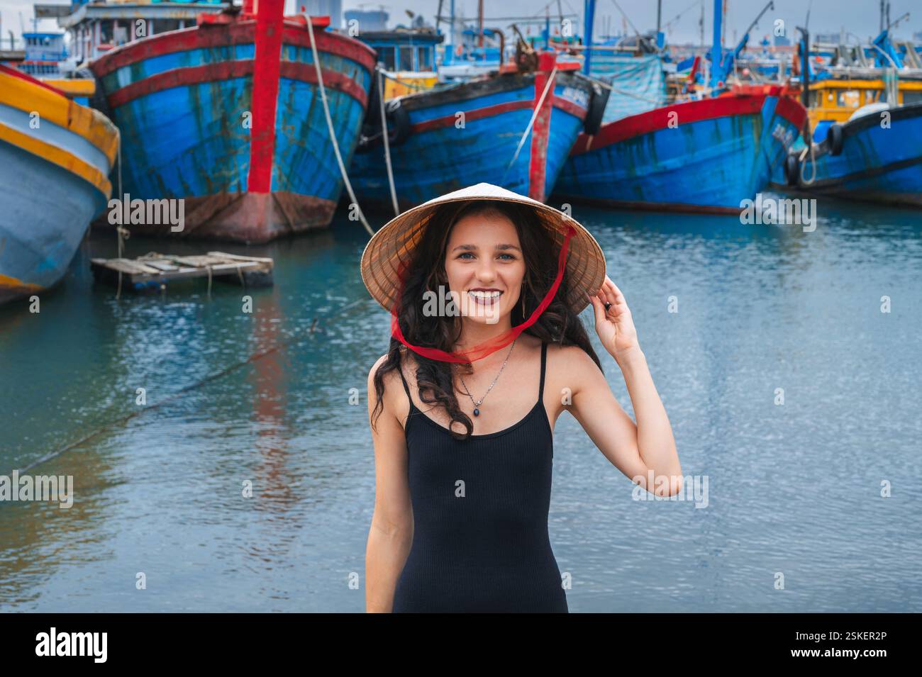 A female traveler wearing a traditional Vietnamese hat inspects ...