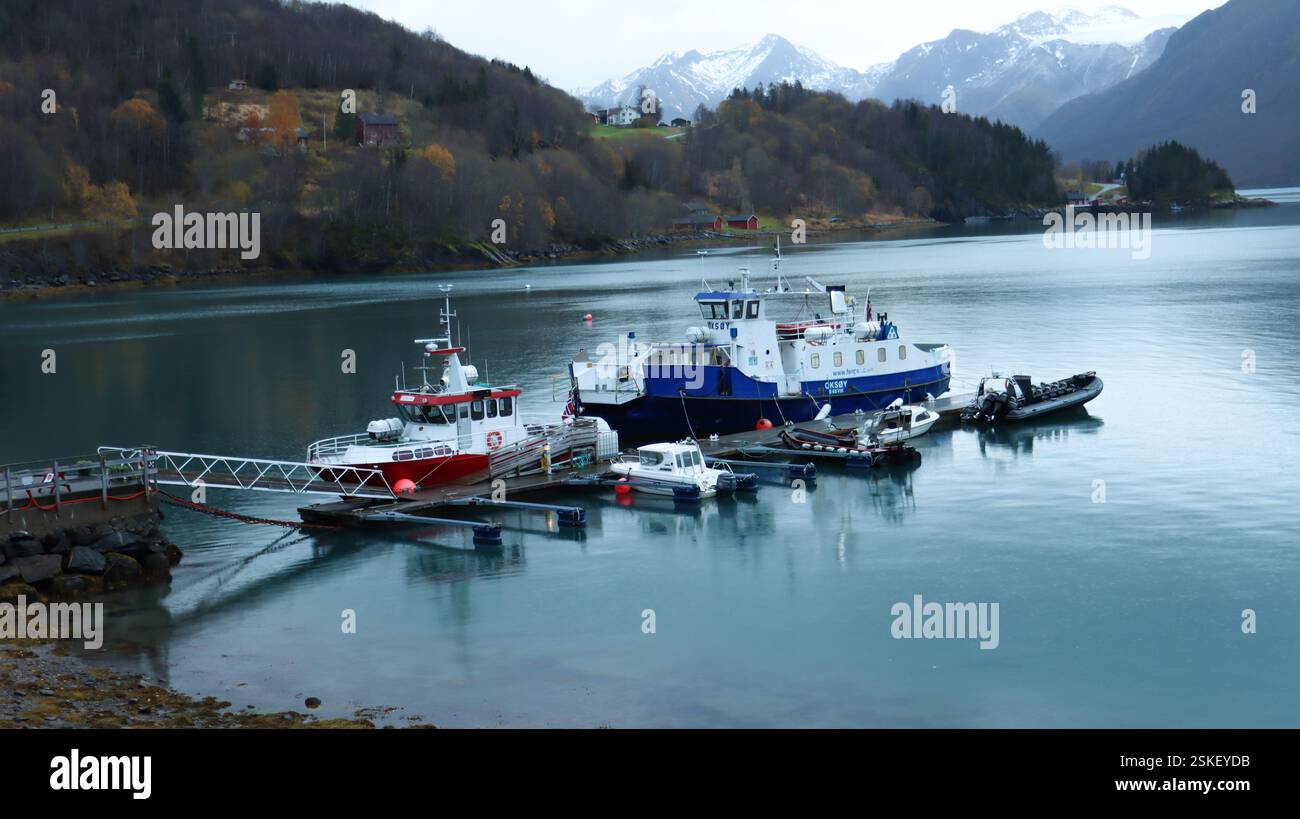 Floating dock on a quiet Norwegian fjord, where several boats are ...