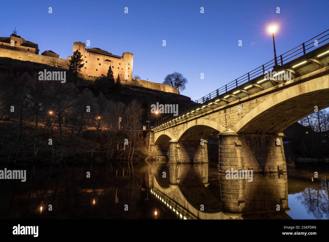 Castle and bridge illuminated at night of the medieval village of ...