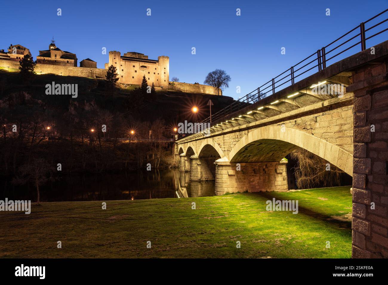 Castle and bridge illuminated at night of the medieval village of ...