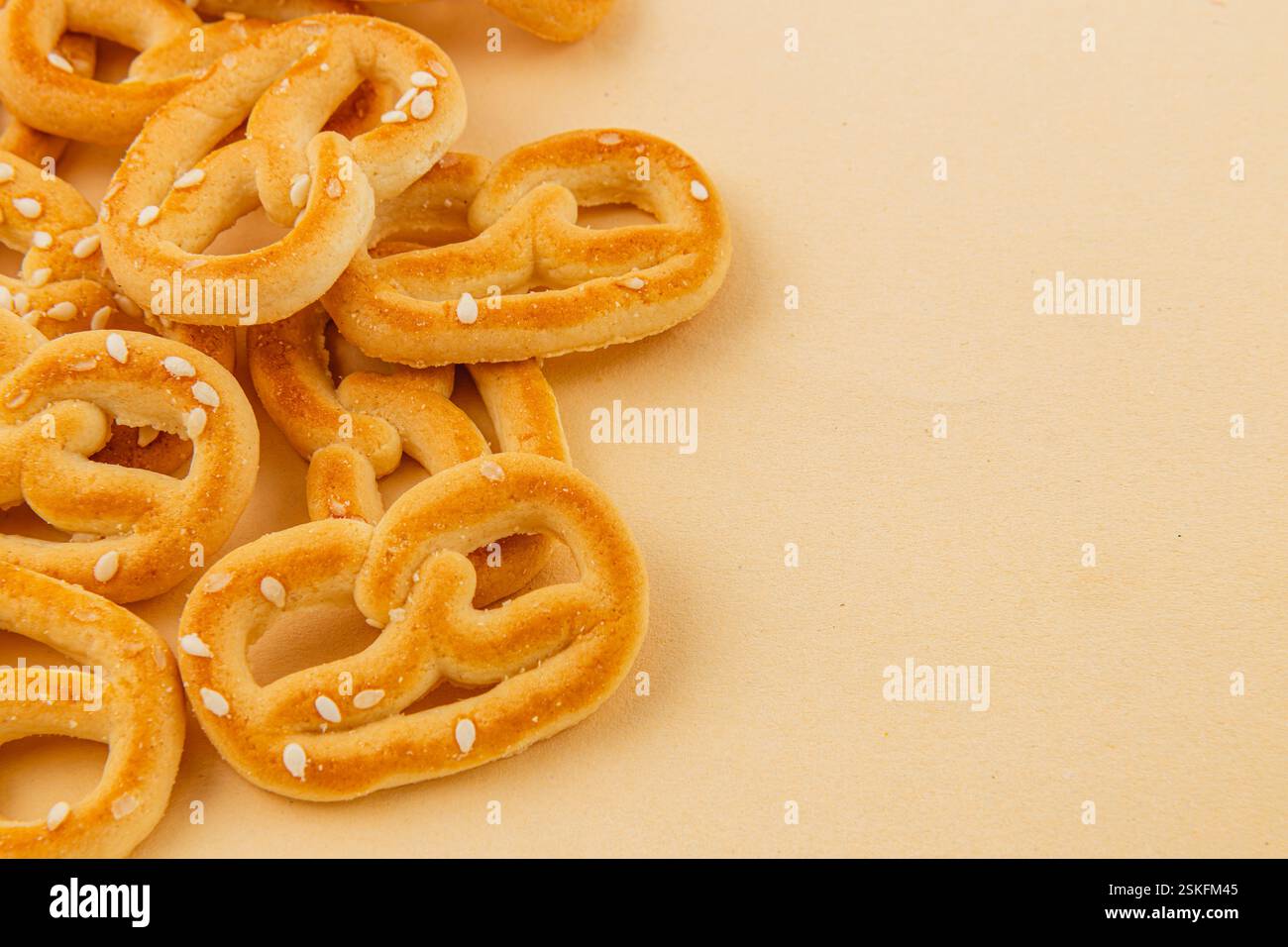 Delicious crispy pretzels are casually scattered on a light background ...