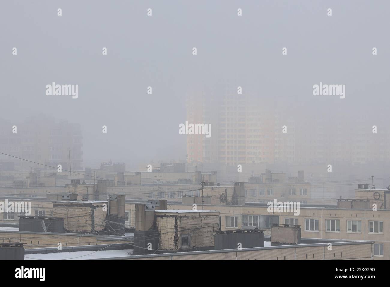 City foggy landscape in a residential area with roofs and silhouettes ...