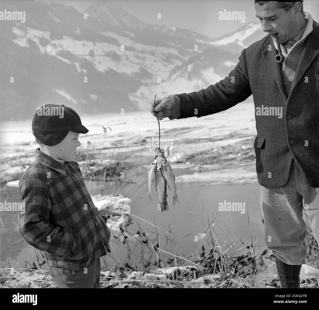 Fischer zeigt einem Jungen Fische aus dem Lauerzersee, Seewen SZ 1965#A ...