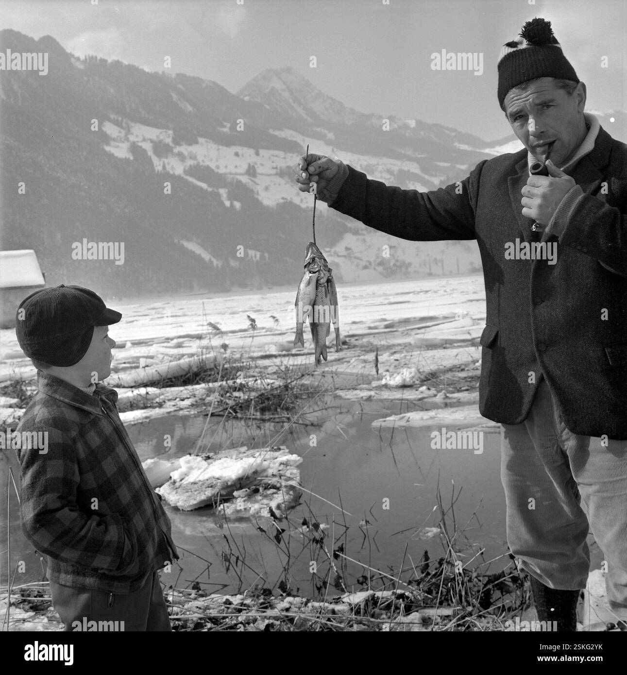 Fischer zeigt einem Jungen Fische aus dem Lauerzersee, Seewen SZ 1965#A ...