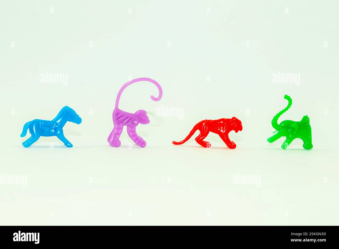 Here are some red, purple and green toys. The toys include tigers ...