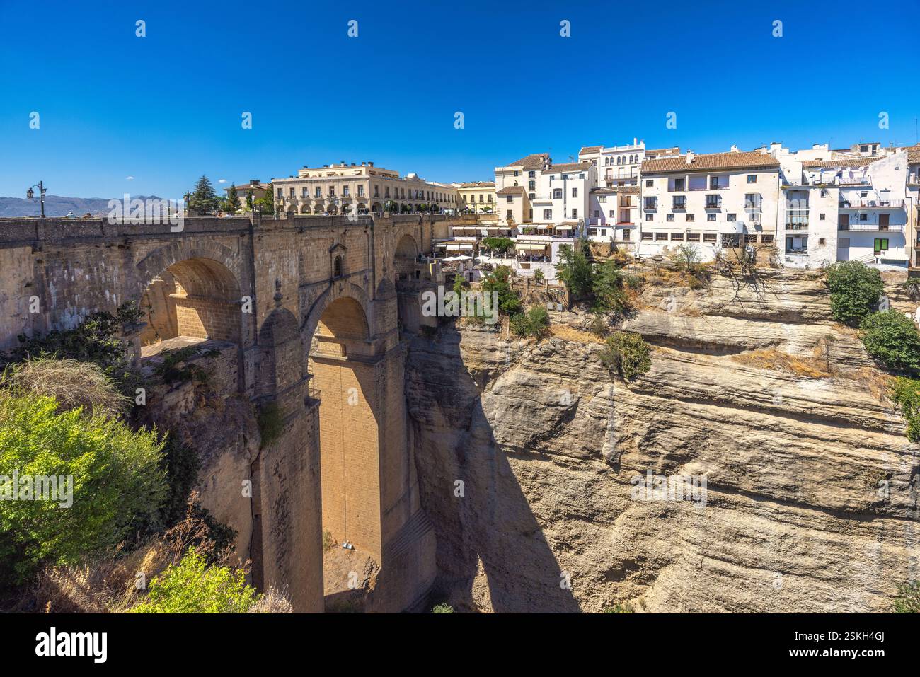 An ancient stone bridge gracefully connects a historic town, perched ...