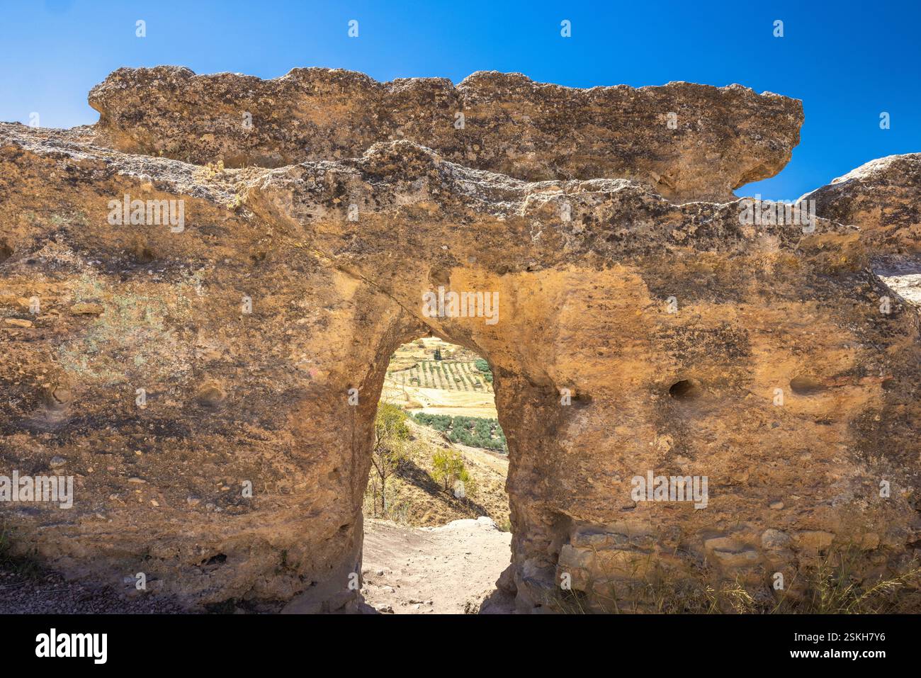 Ronda town in Spain. Stone archway framing a sun-drenched landscape ...