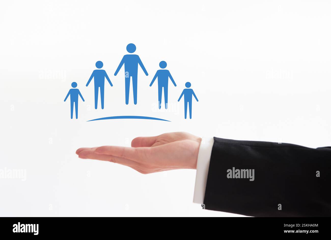 A hand in a suit holds a group of blue little people icons Stock Photo ...