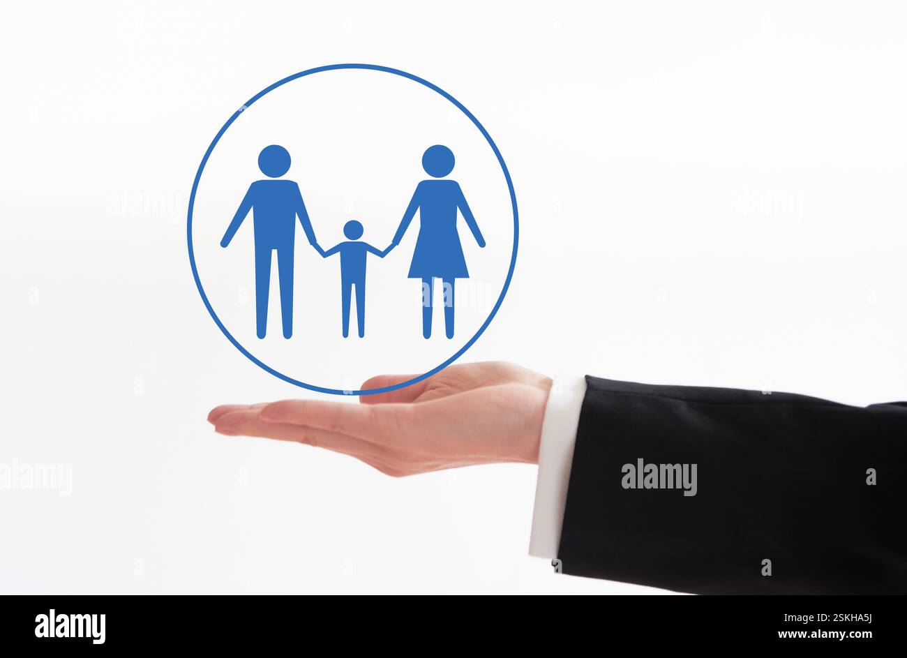 A hand in a suit holds a blue family symbol with parents and children ...