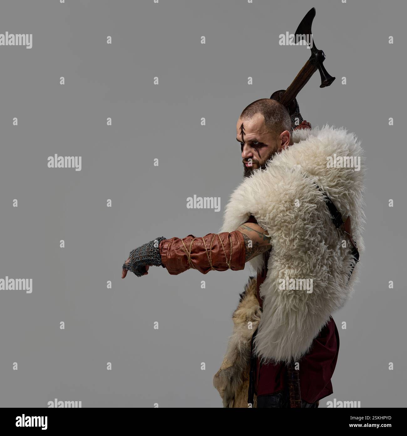 Man portraying medieval Viking warrior in fur cloak and leather armor ...