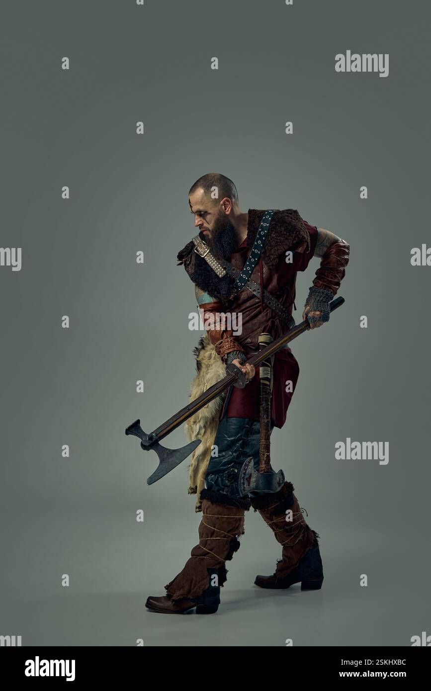 Viking warrior gripping double-headed axe, crouching in battle-ready ...