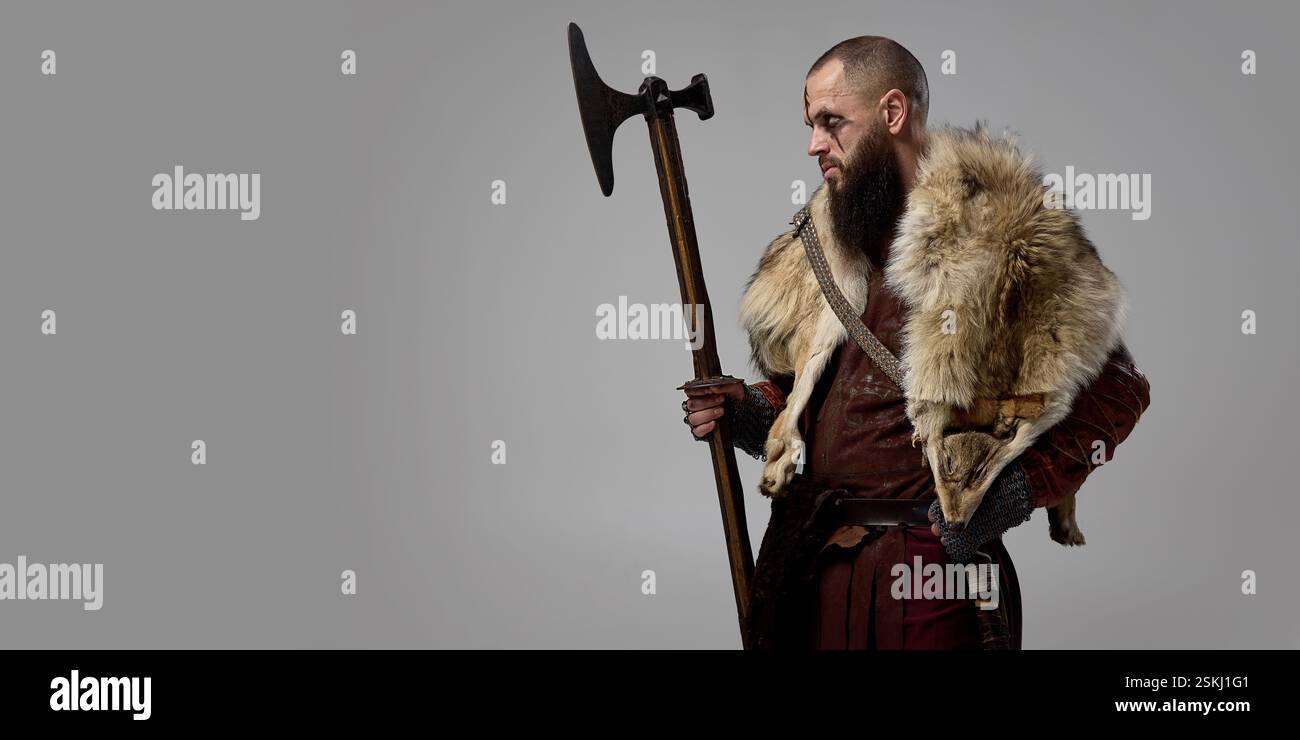 Medieval Viking warrior dressed in armor, with massive axe, showing ...