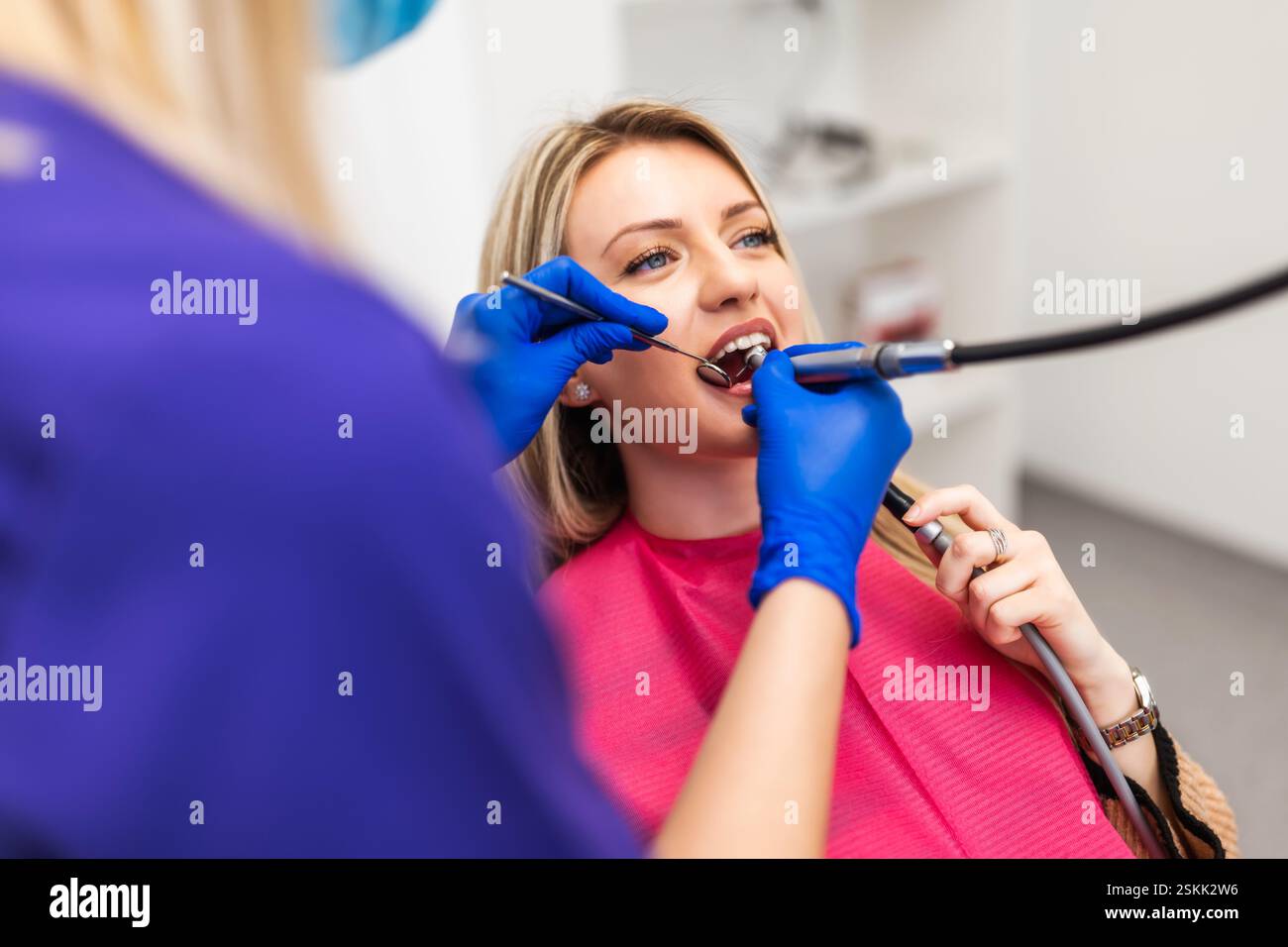Dentist drilling the teeth of the patient. Young woman having her teeth ...