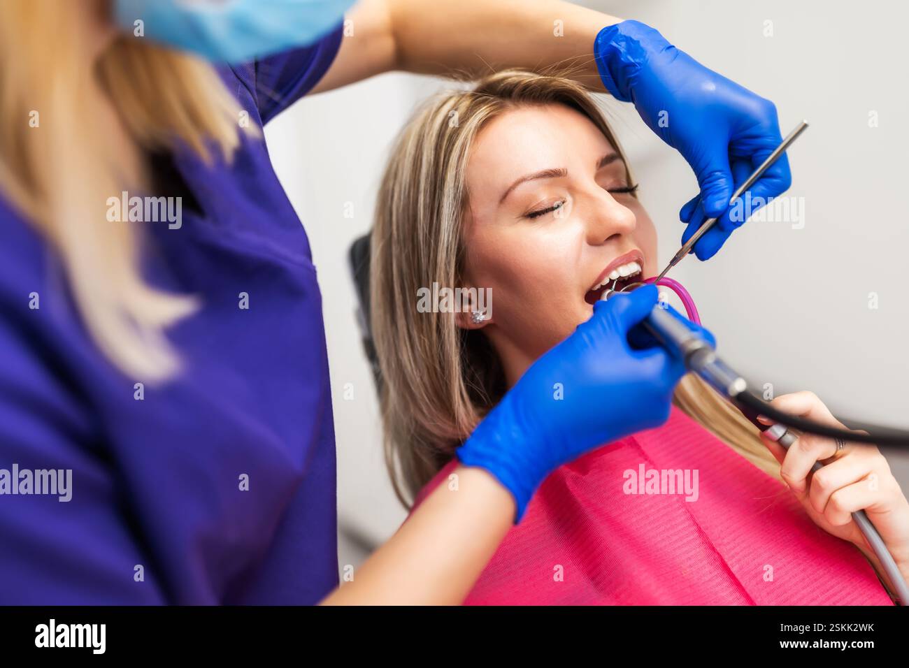 Dentist drilling the teeth of the patient. Young woman having her teeth ...