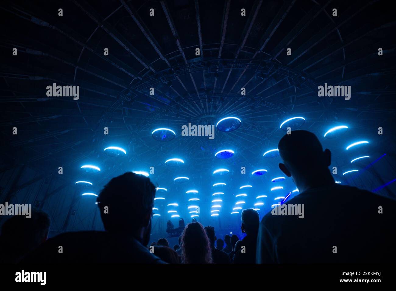 Energetic Crowd Enjoying an Event Under Vibrant Blue Lights in ...