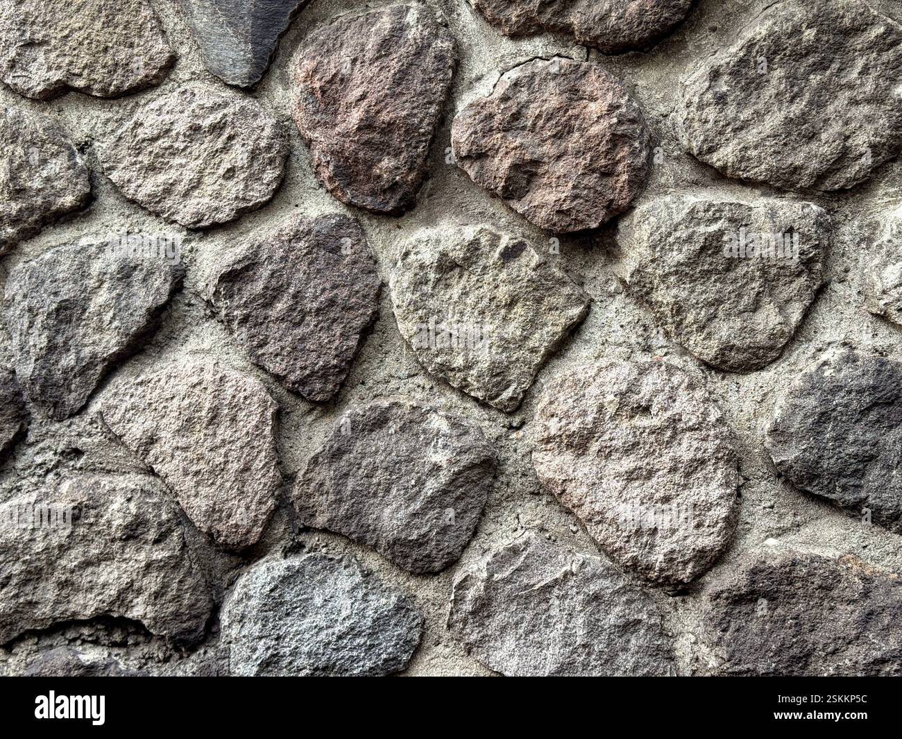 Natural random cut grey cobblestone cemented on a wall surface. Series ...