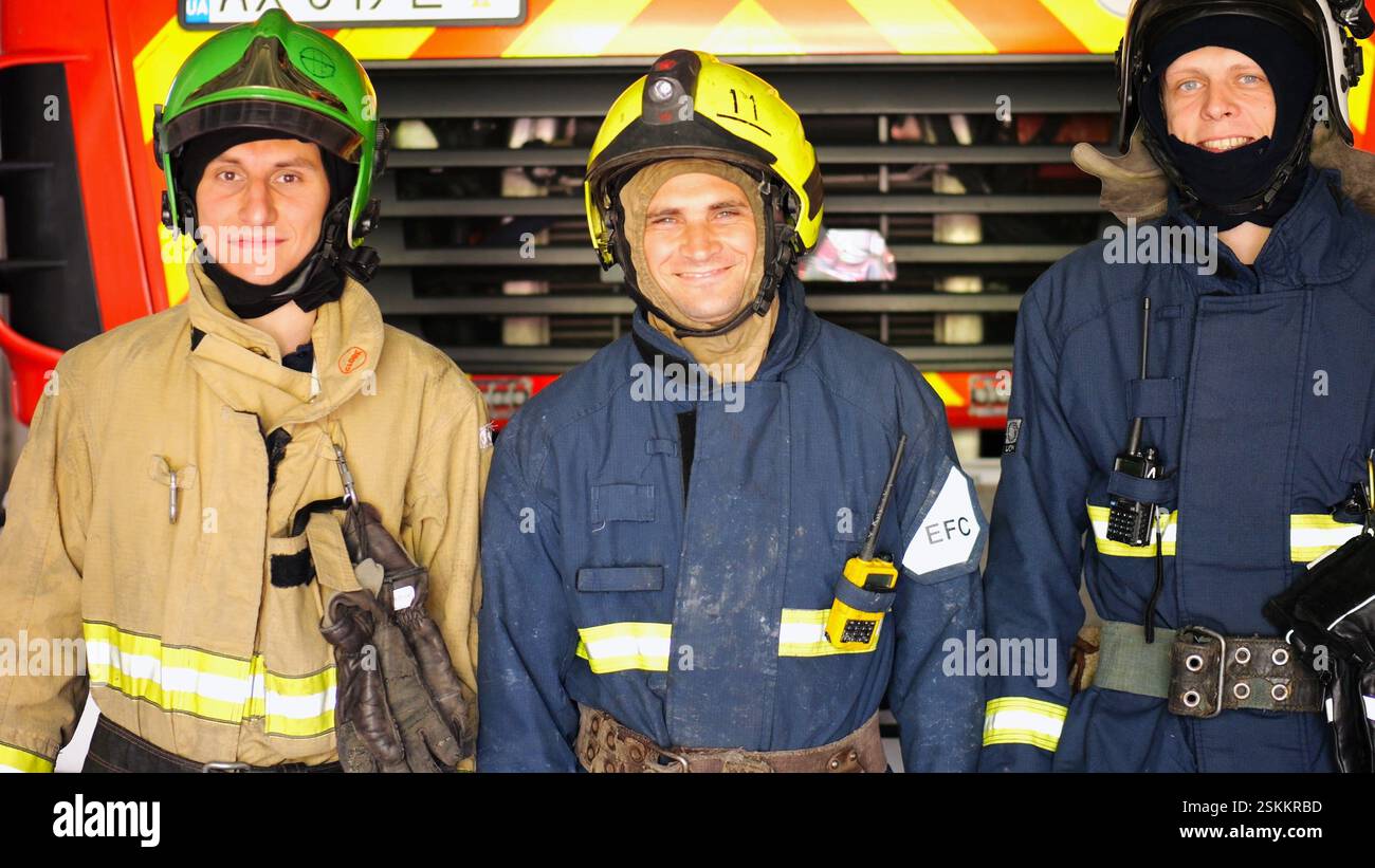 Portrait of young happy fireguards in protective uniforms against ...