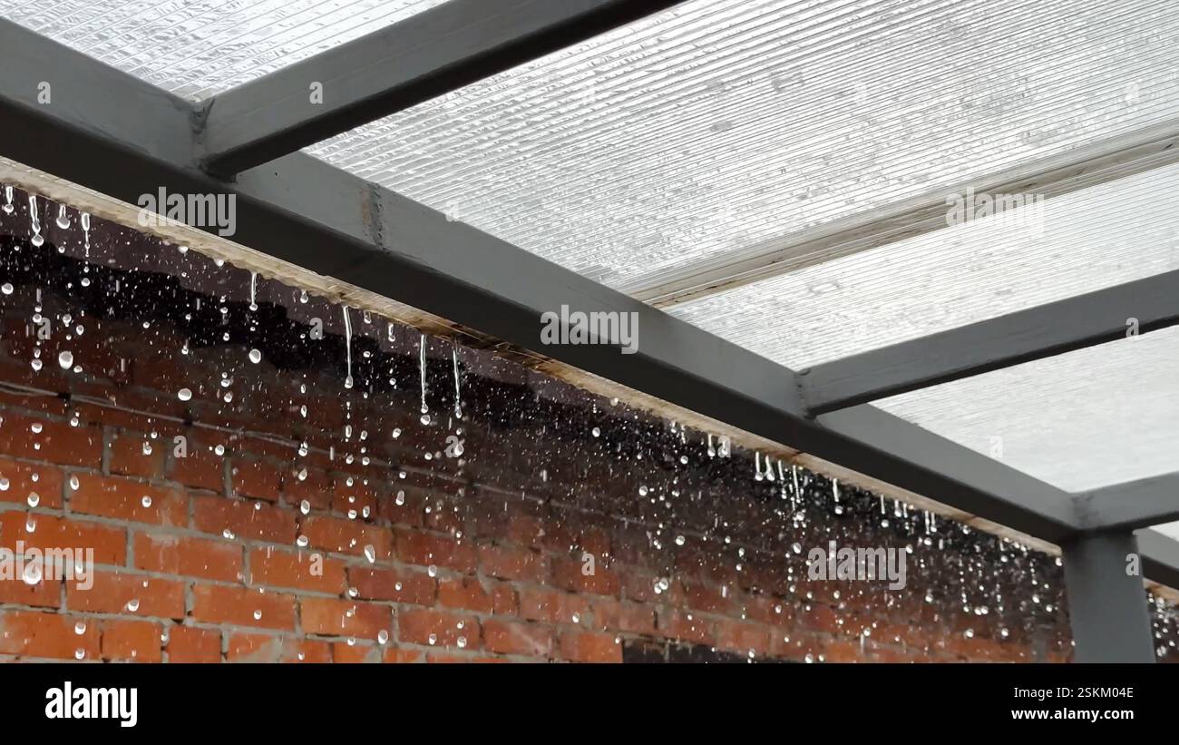 Heavy rain drumming on the transparent plexiglass roof. Beautiful rainy ...