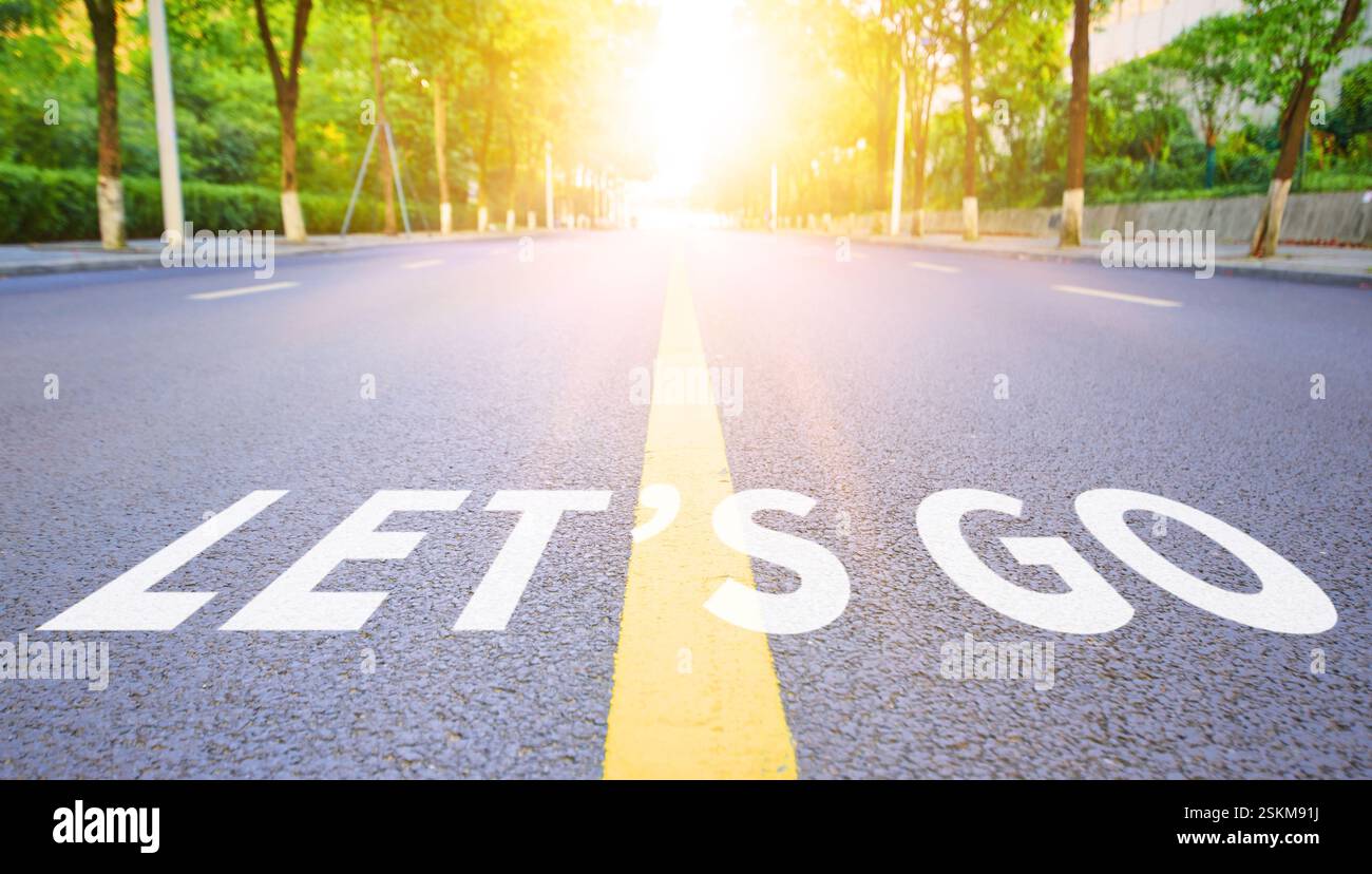 A straight road stretches to the distance where the sun shines, and on ...