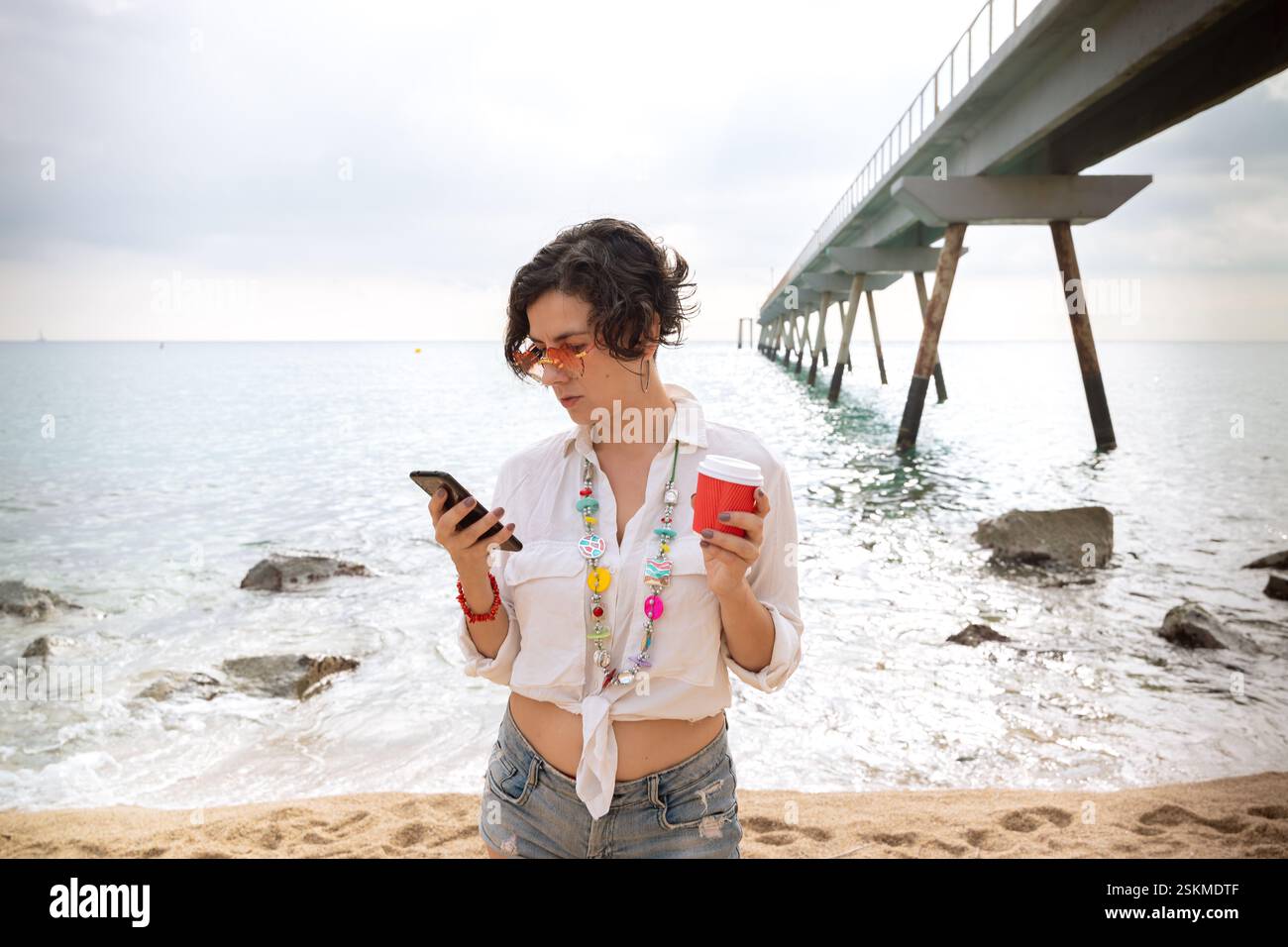 Caucasian woman using an app on her smartphone on the beach Stock Photo ...