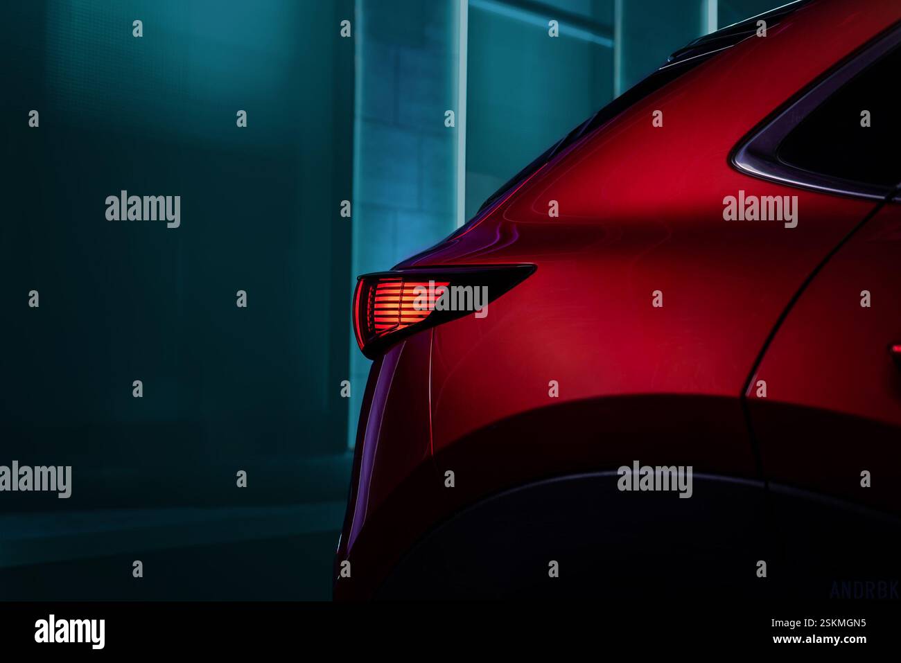 Side view of red car rear side part at night. Close-up view of of rear ...