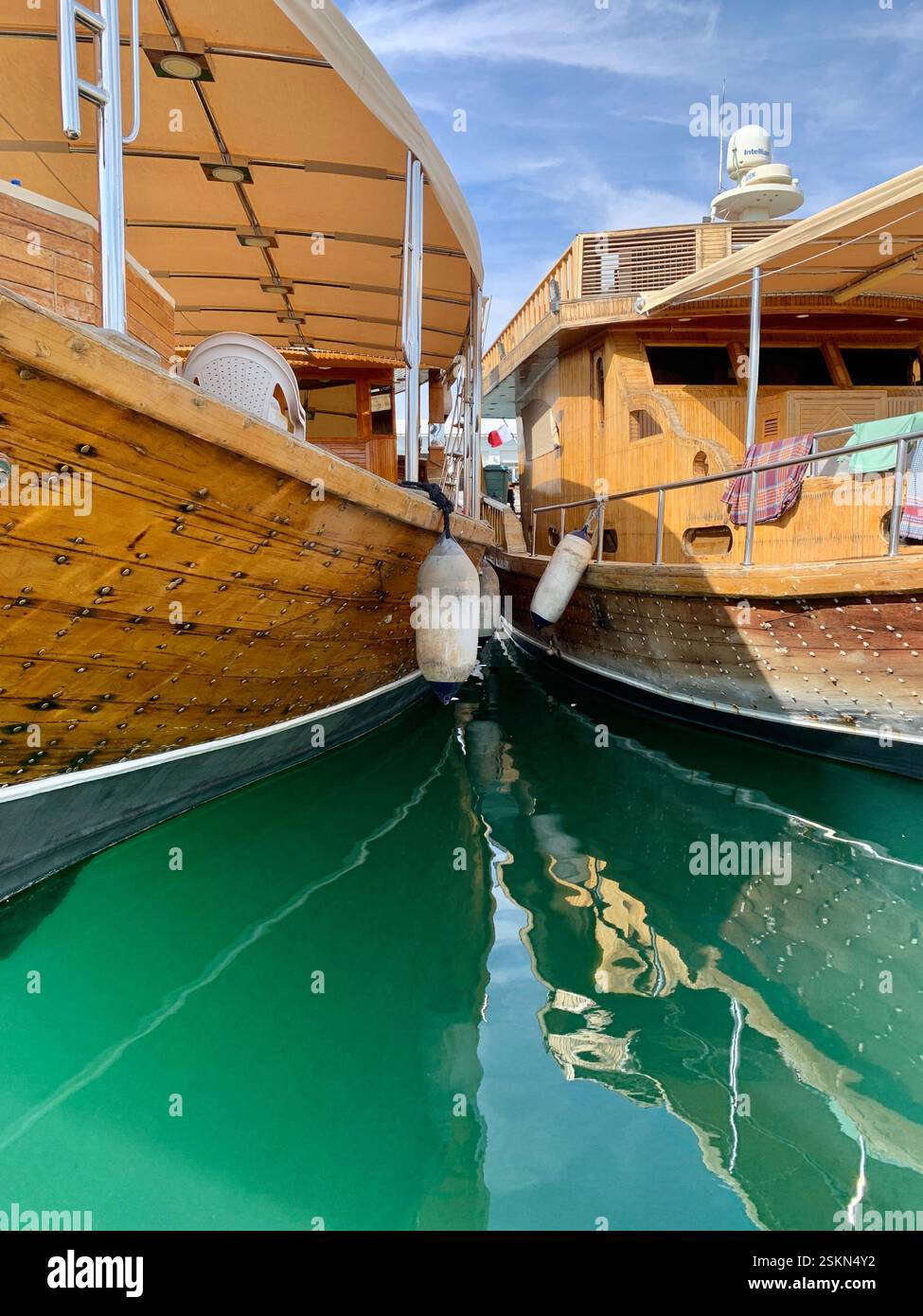 wooden boats on teal water at Doha old Port Stock Photo - Alamy