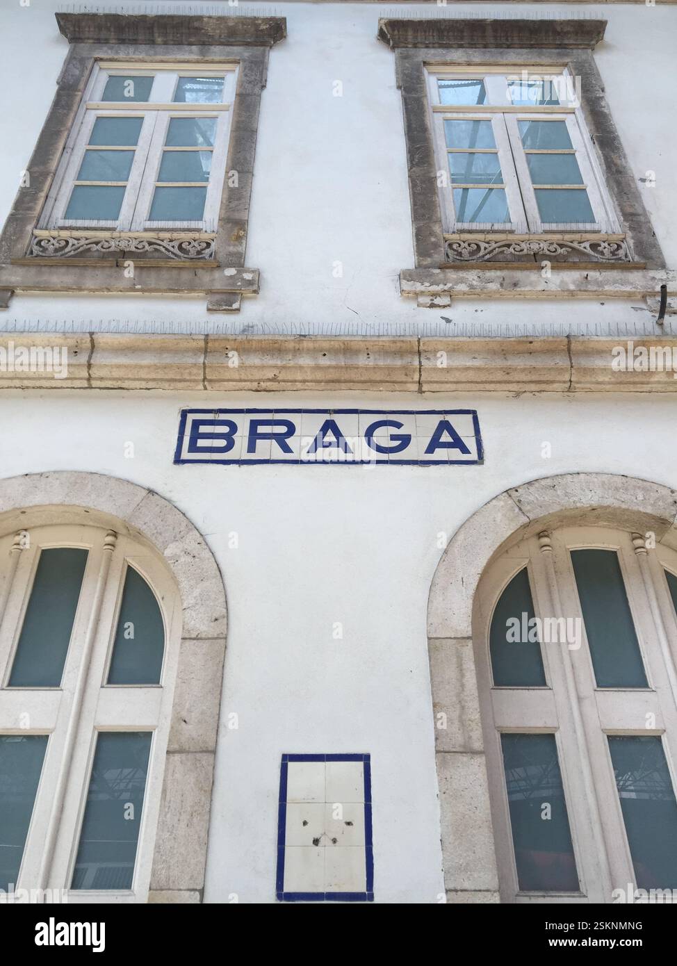 Braga train station stands tall with pristine white walls adorned by a vibrant blue tiled sign ...